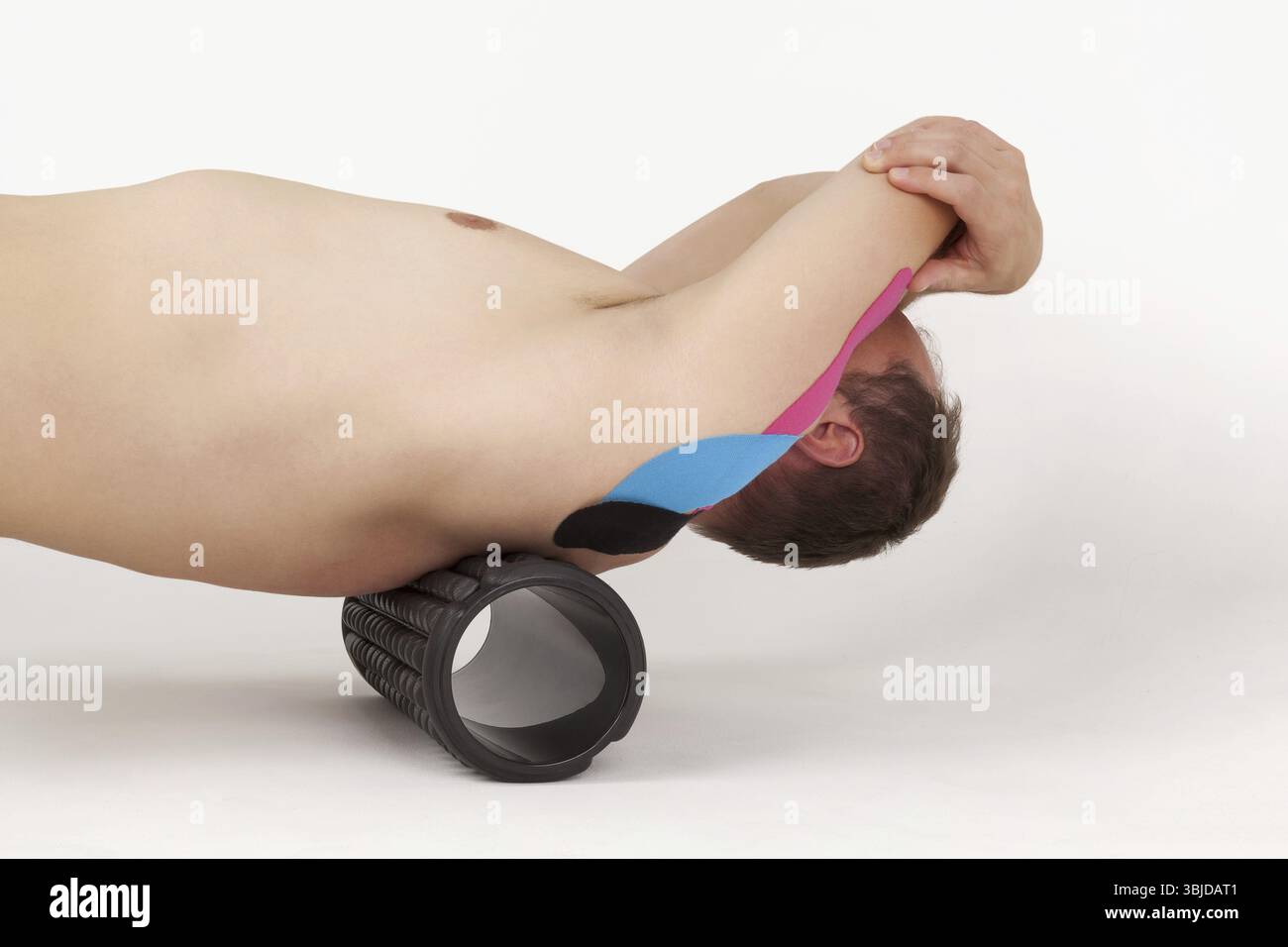 Upper Back Massage with foam roller. Half body length portrait isolated ...