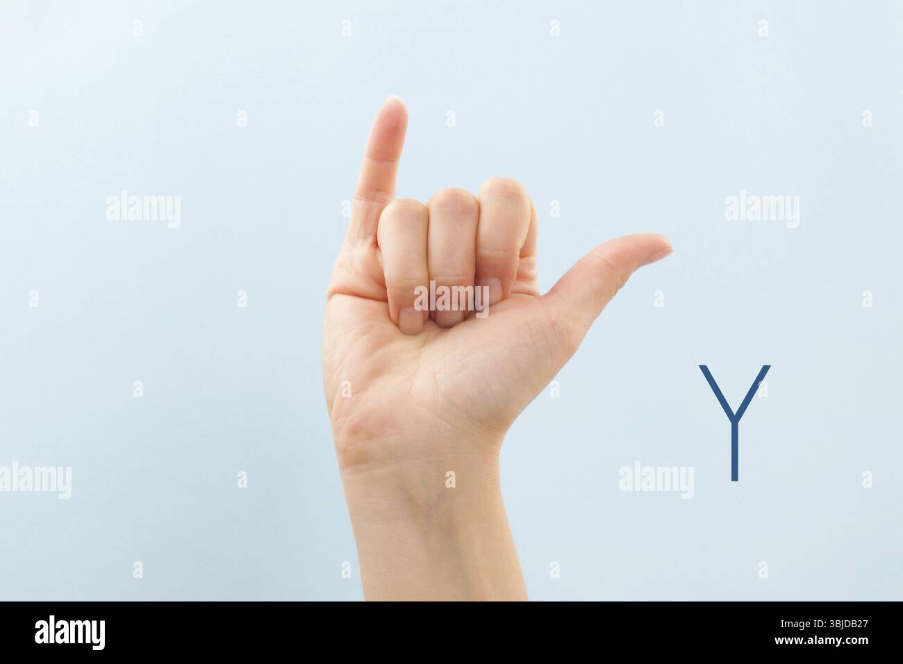 American sign language. Female hand showing letter Y isolated on blue ...