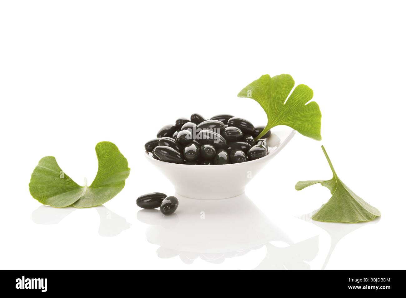 Ginkgo leaves with gel capsules isolated on white background with ...