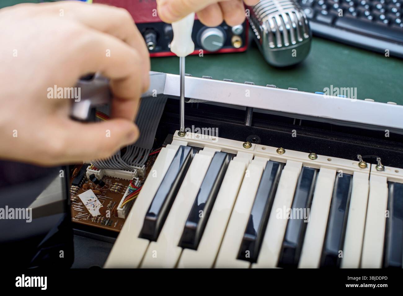 Male hand fixing midi keyboard controller Stock Photo - Alamy