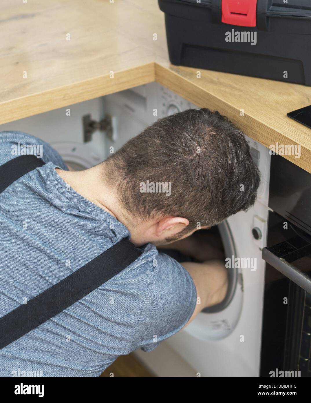 Professional plumber repairing washing machine hi-res stock photography ...
