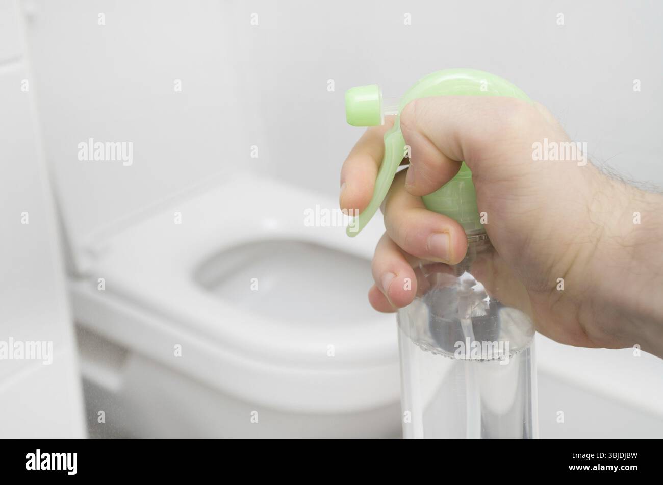 Male hand spraying toilet air freshener at home Stock Photo - Alamy