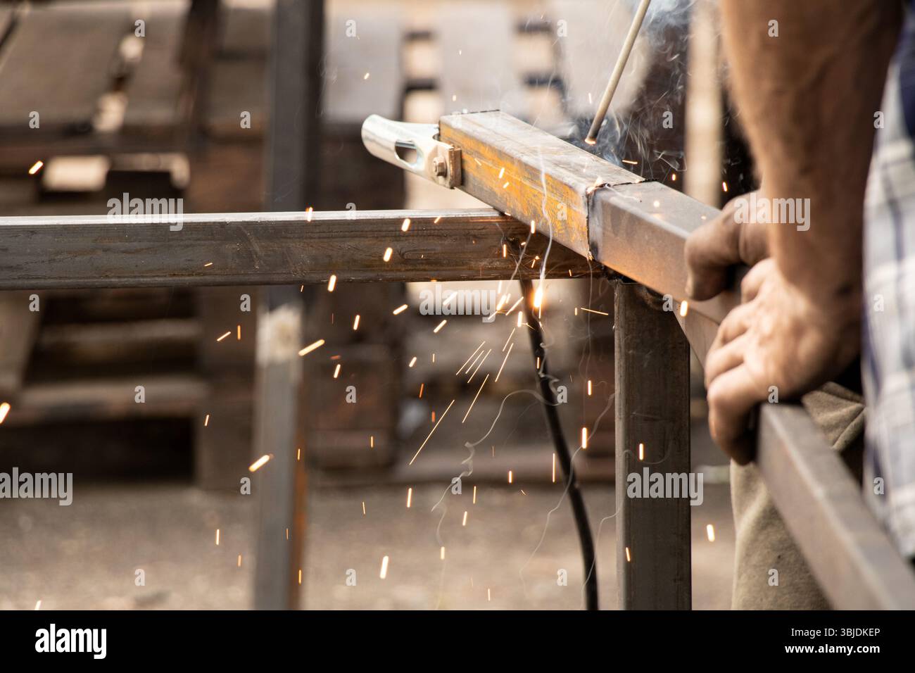Welding metal parts with sparks and smoke - the work process of a ...