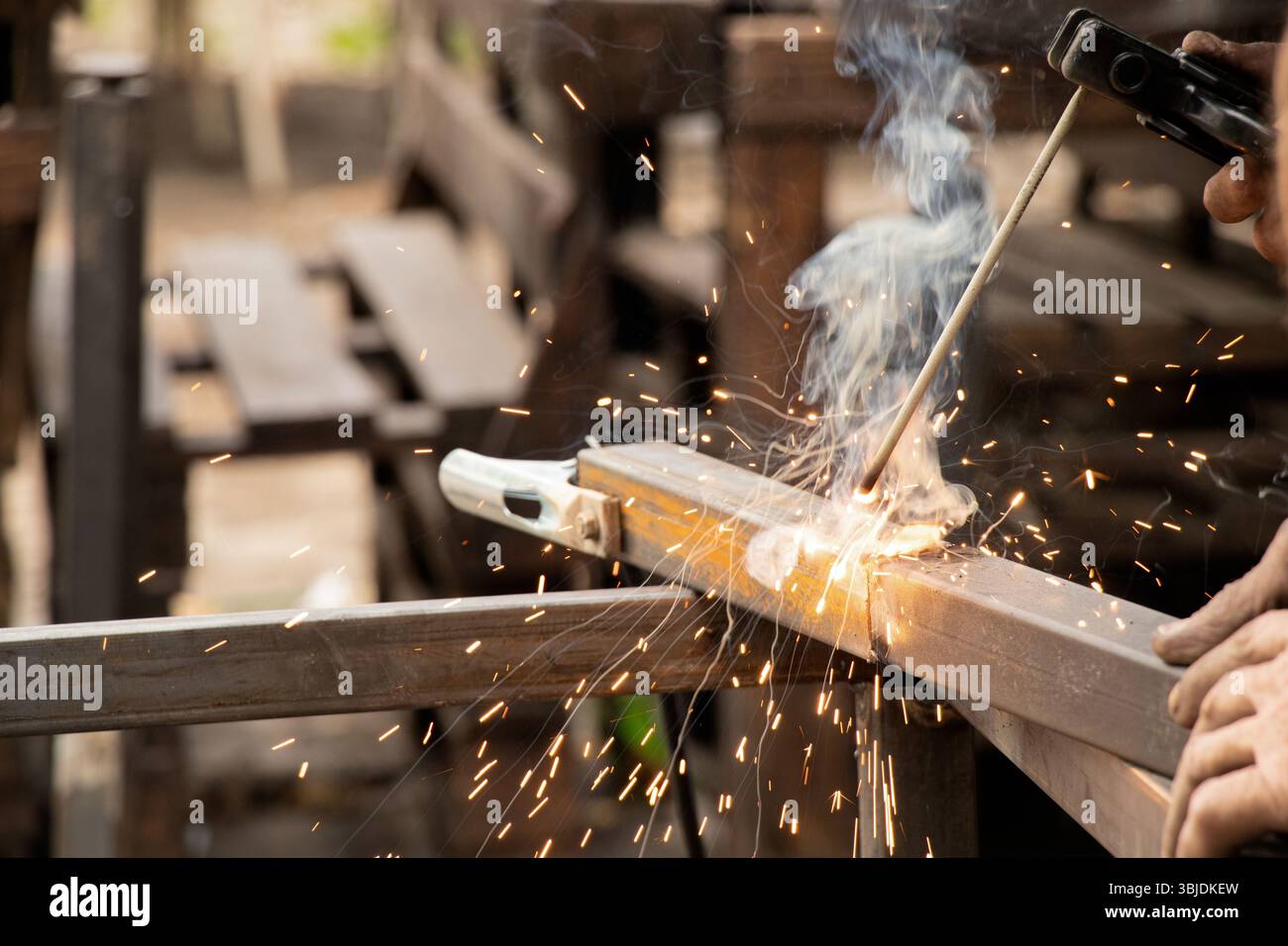Welding metal parts with sparks and smoke - the work process of a ...