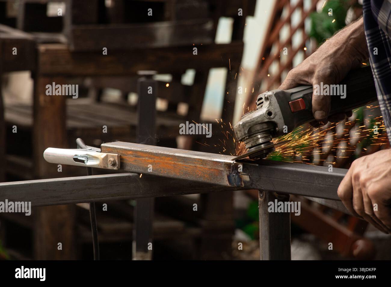 Grinding a weld on metal structures with a grinder, a master working on ...