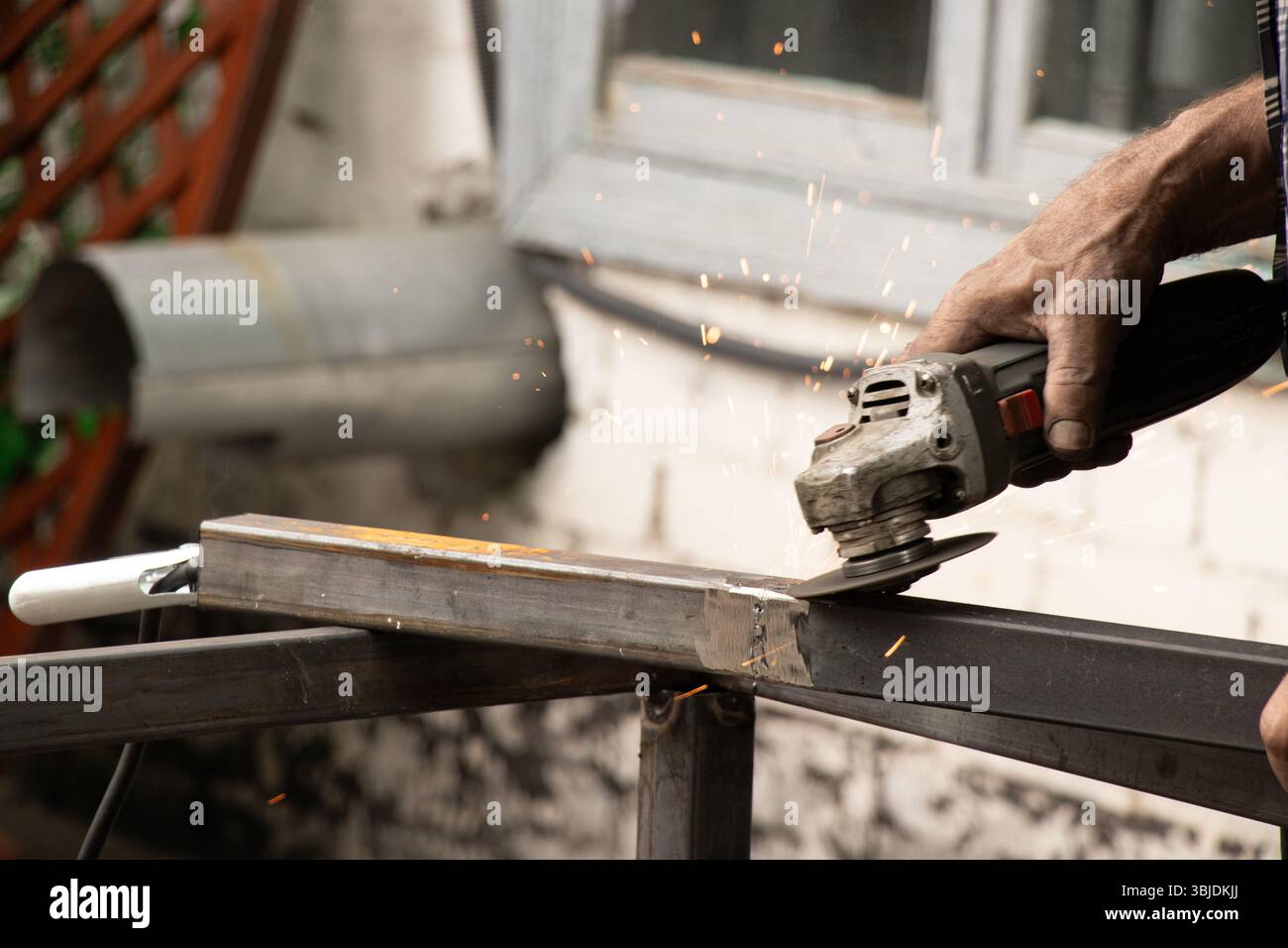 Grinding a weld on metal structures with a grinder, a master working on ...