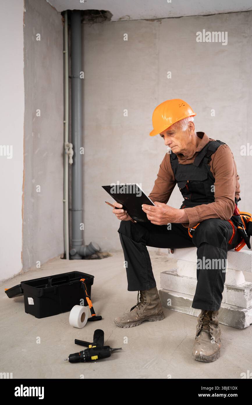 Civil engineer elderly man with clipboard reading checklist making ...