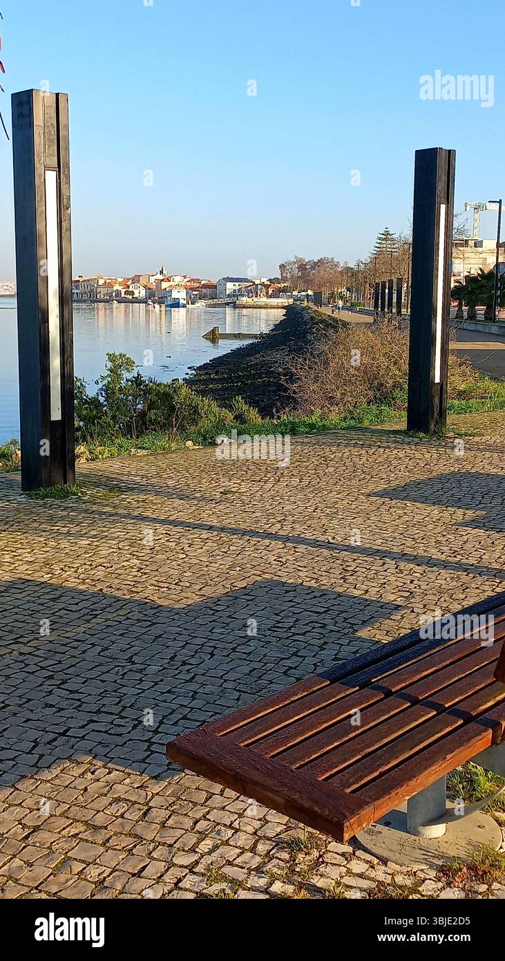 Quiet dawn scene at Seixal promenade featuring empty bench cobbled path ...