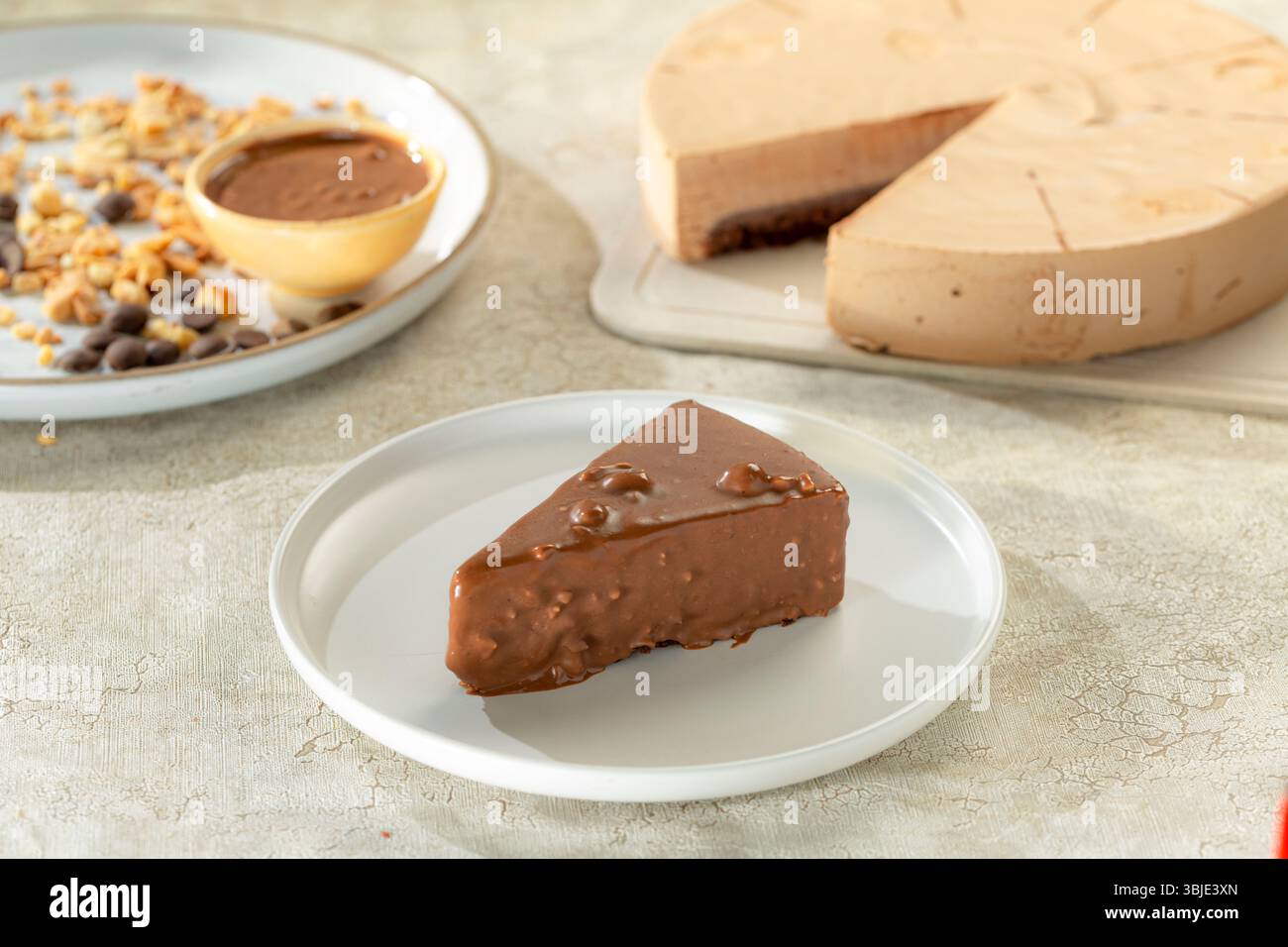 Cold cake slice topped with nuts and hazelnut cream, light background ...