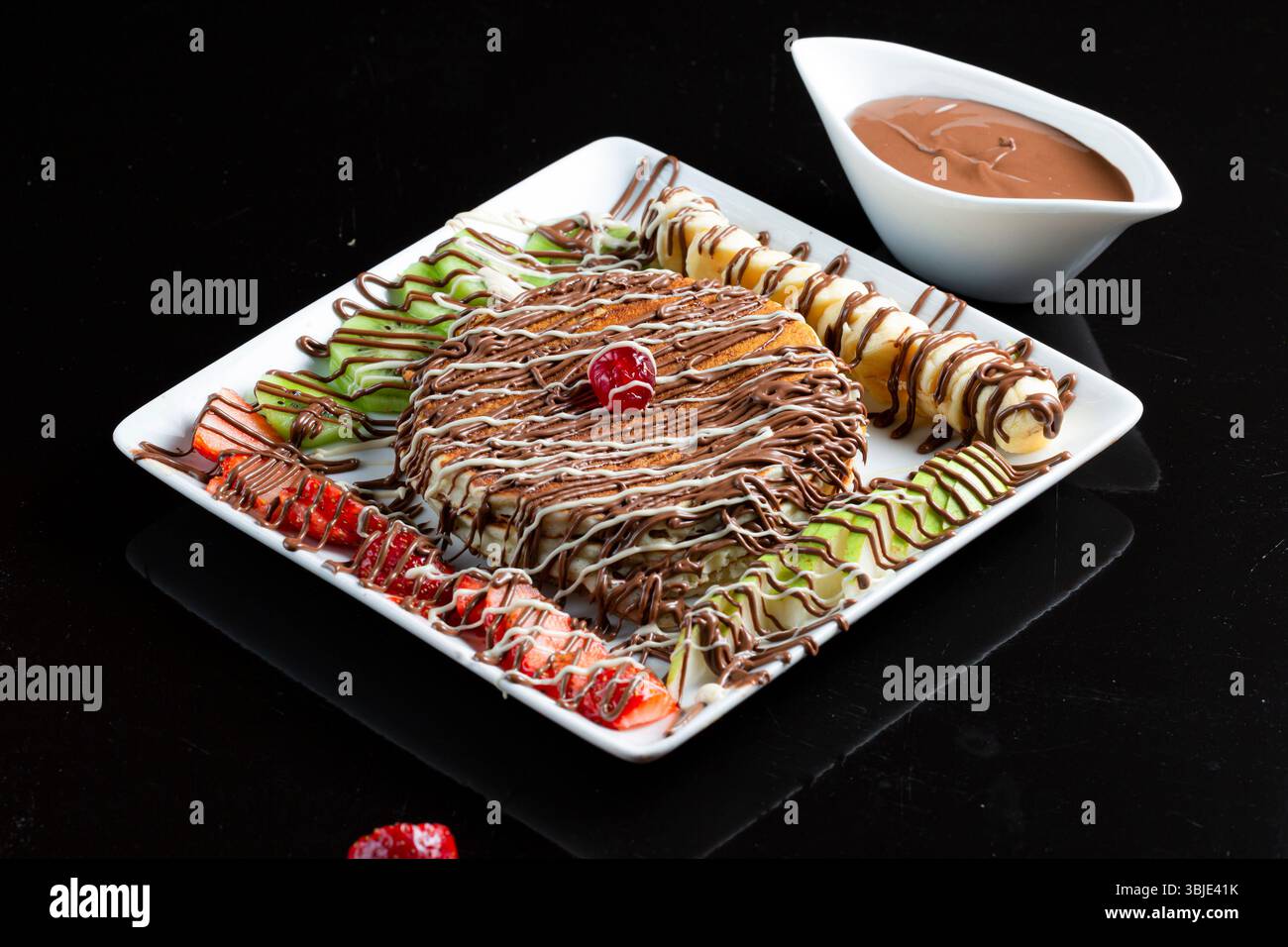 Chocolate pancake plate, served warm on black background, decadent and ...