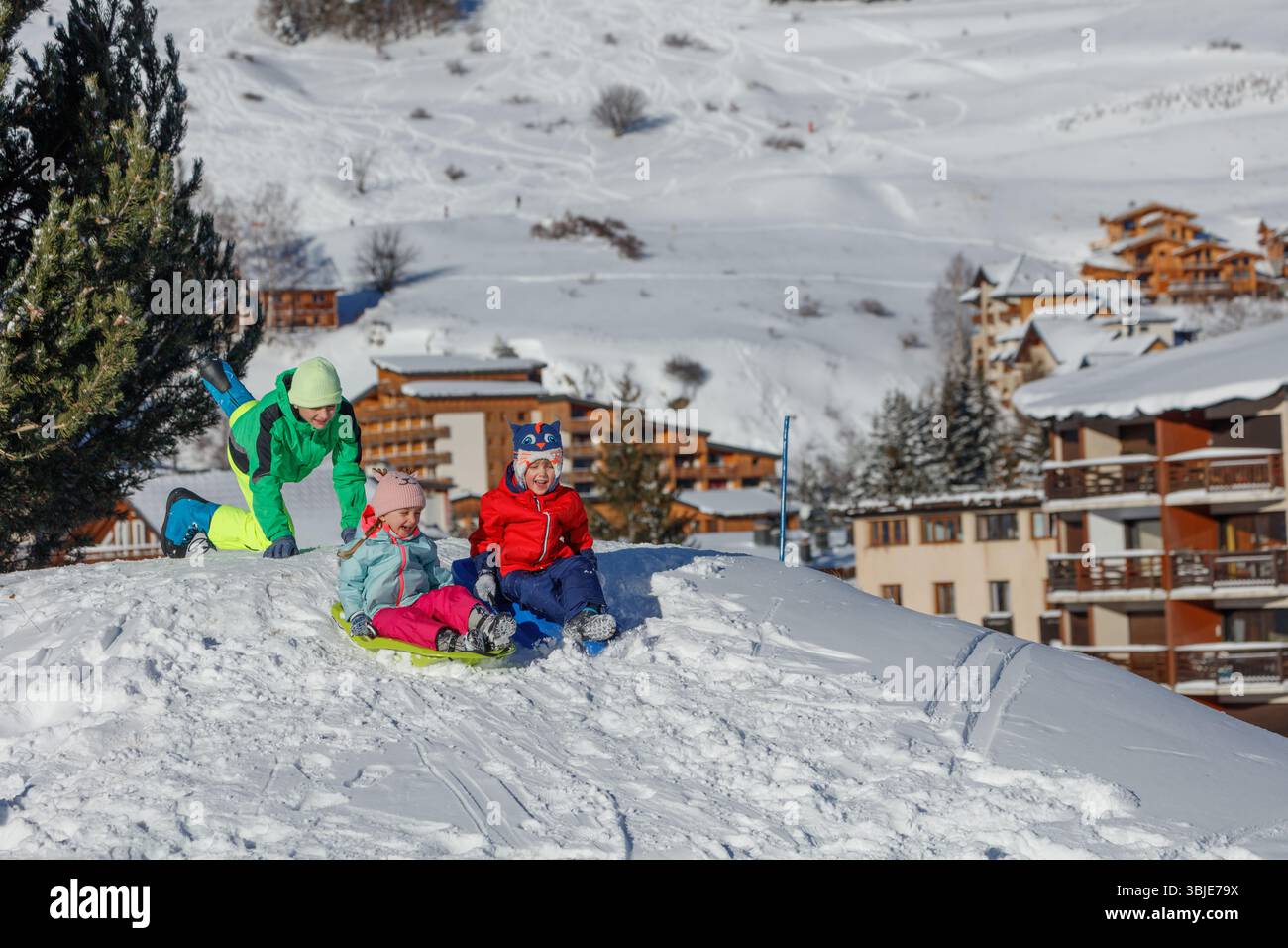 Three happy kids sled downhill, full of laughter and excitement Stock ...