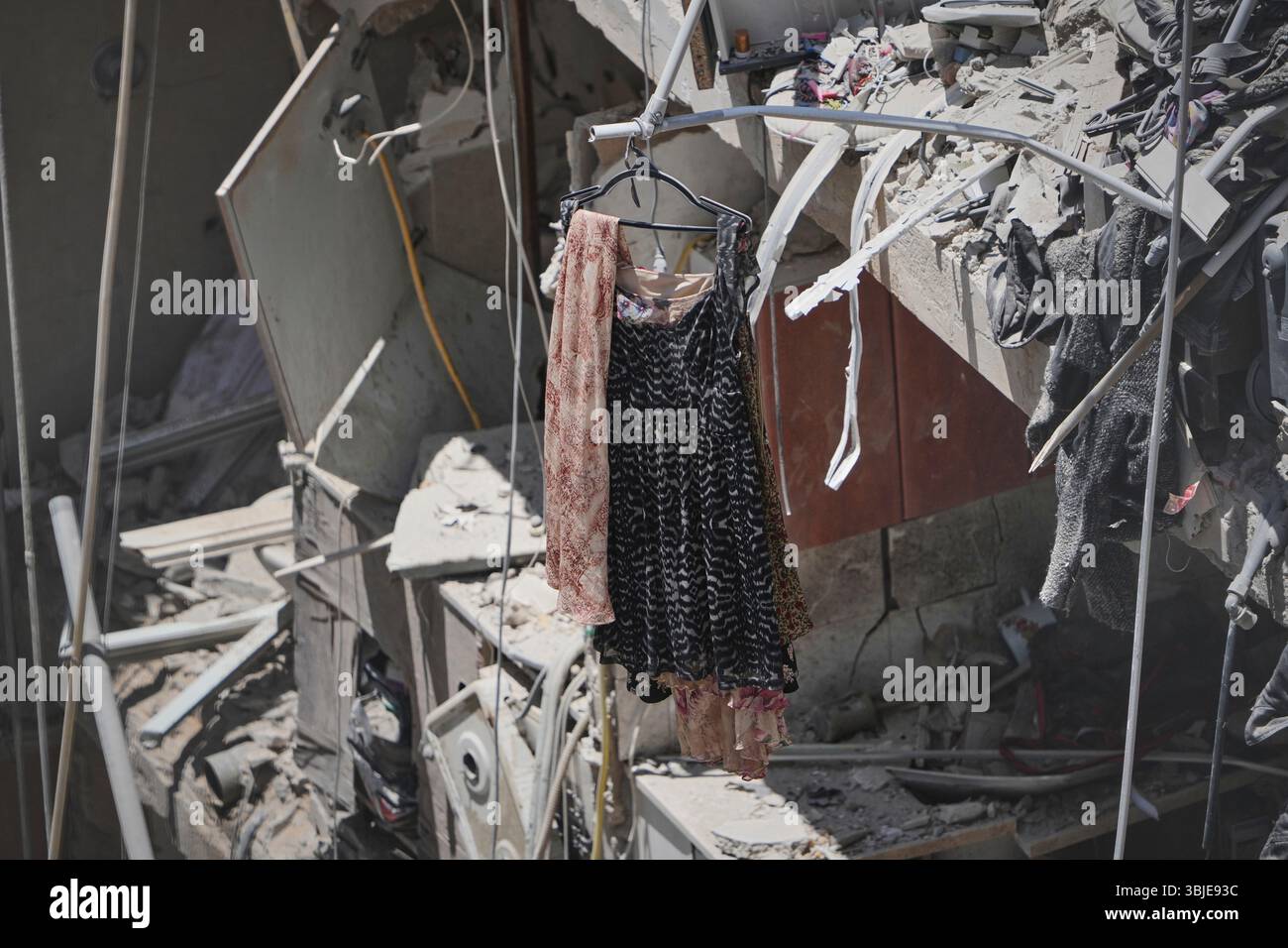 A dress hangs amid the rubble of residential buildings destroyed by an ...