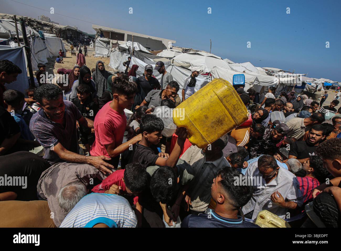 Palestinians carry jerry cans filled with water distributed by a water ...