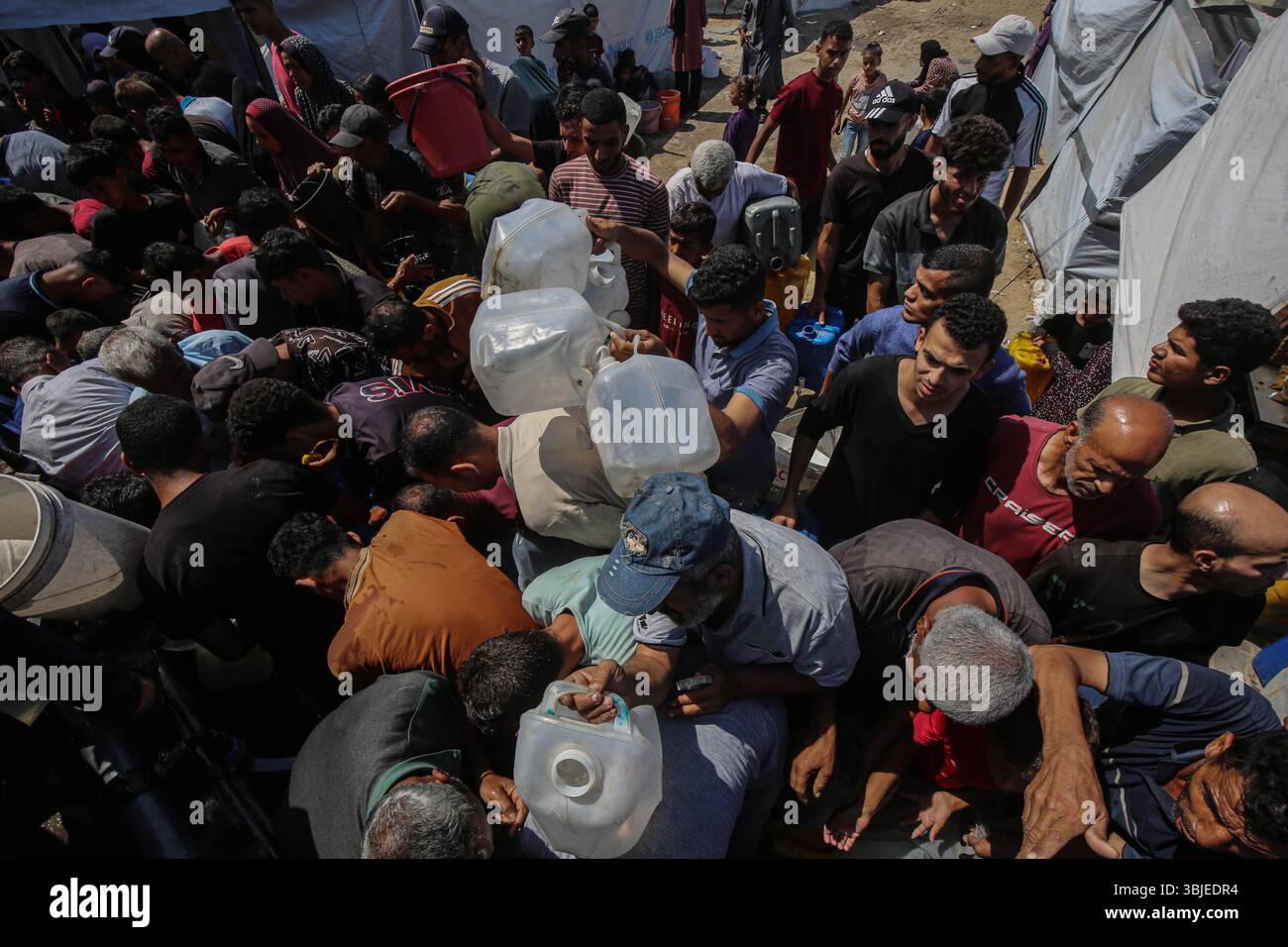 Palestinians carry jerry cans filled with water distributed by a water ...