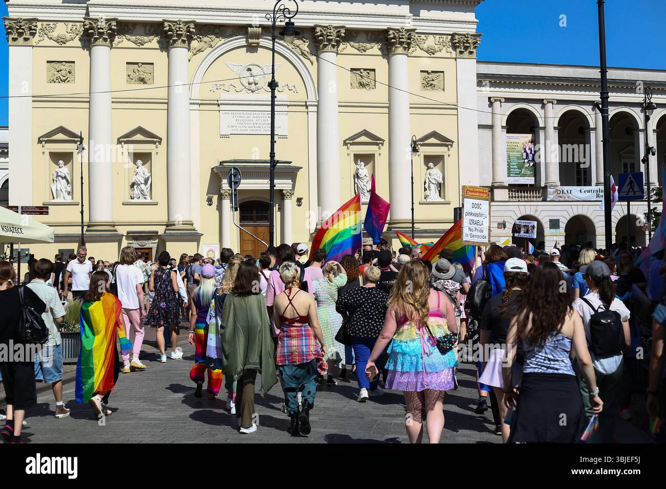 Warsaw, Poland. 14th June, 2025. Participants with rainbow flags march past a church building ...
