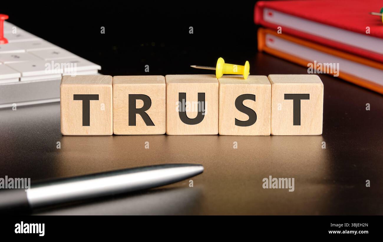 The concept word TRUST is assembled from wooden cubes. Investment based ...