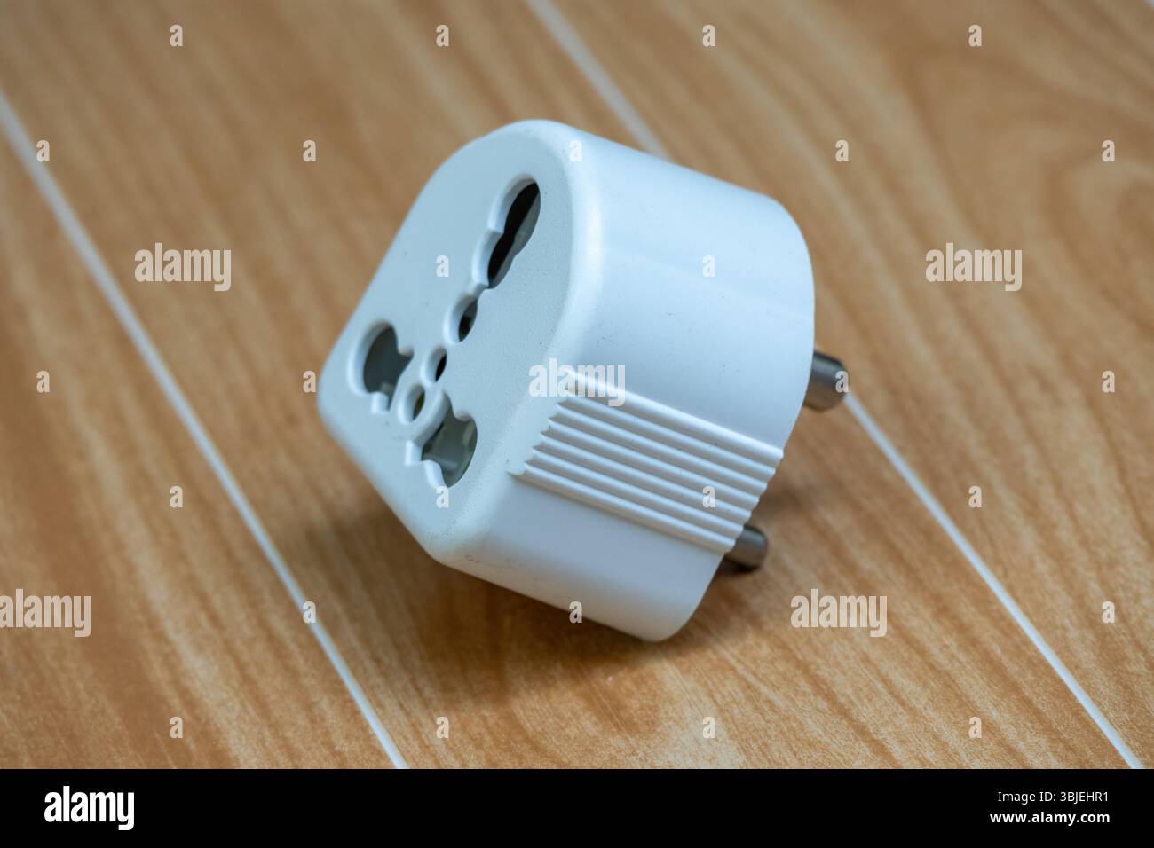 Old white three pin electrical socket on a wooden surface. Close-up of ...