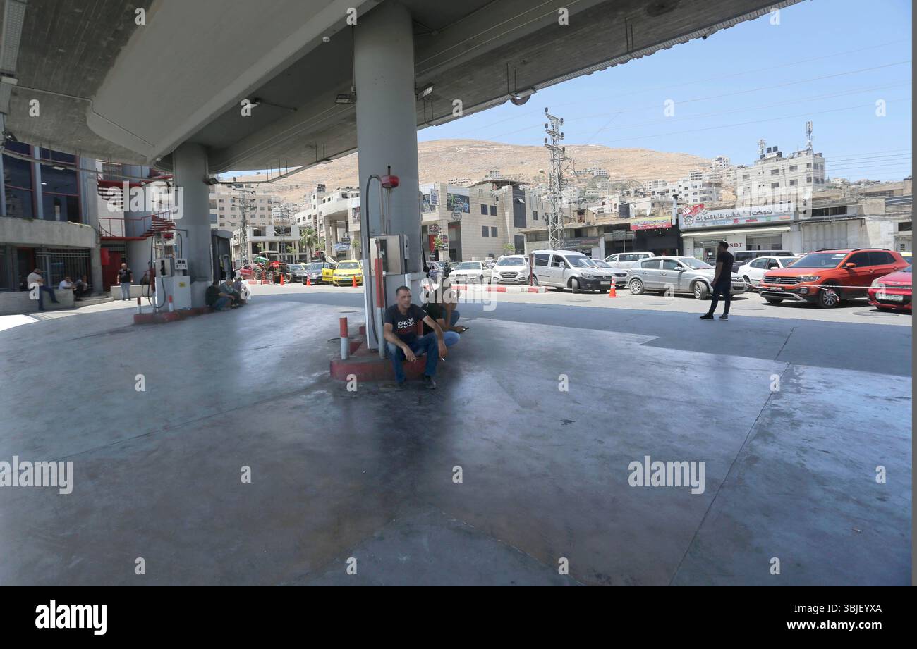 Nablus, Palestine. 15th June, 2025. Palestinians wait at a gas station ...