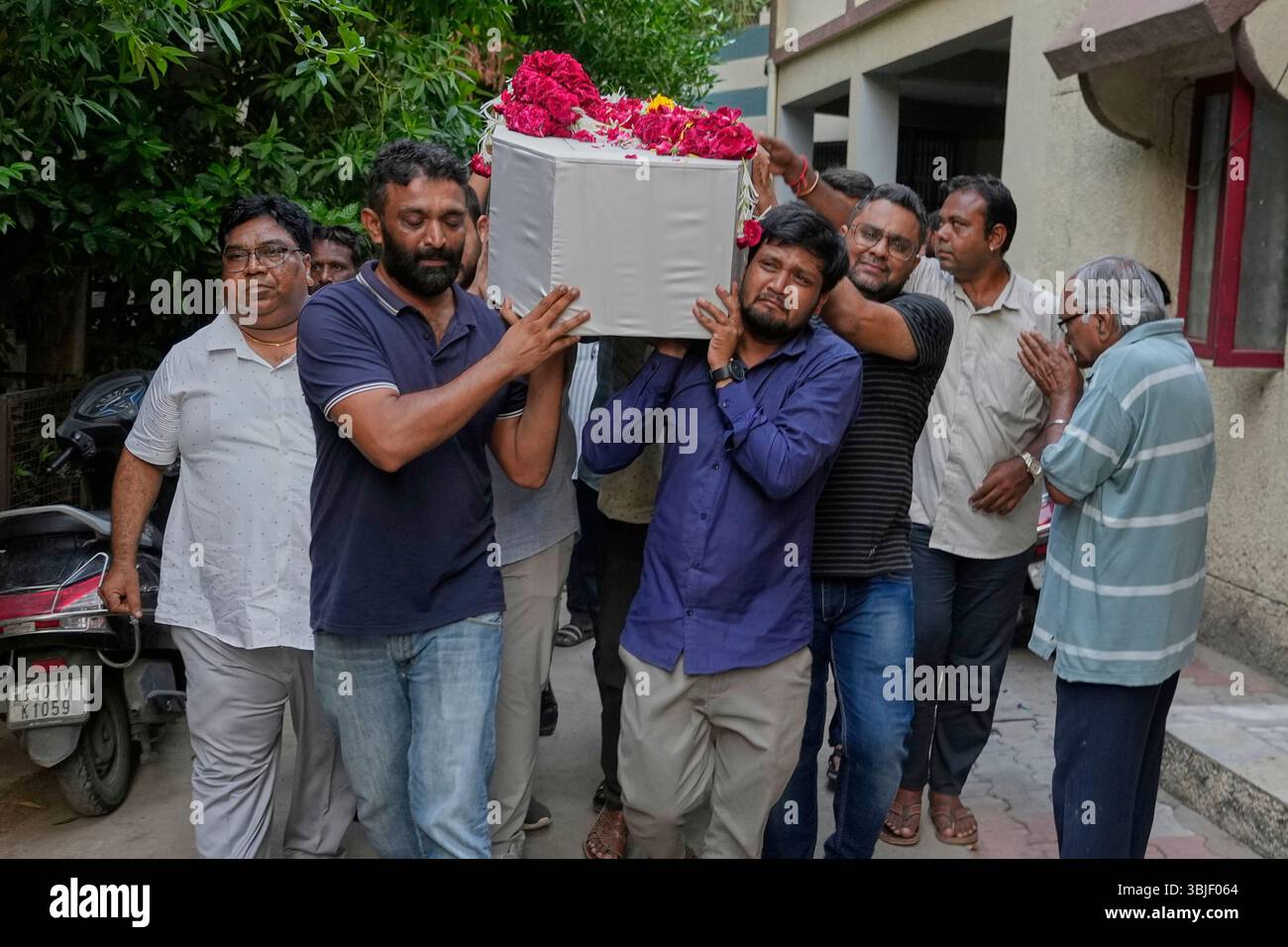 Relatives and neighbors carry the coffin containing the remains of ...