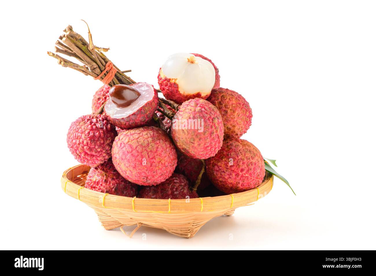 Juicy Lychee with cut in half and leaves on bamboo basket isolated on ...