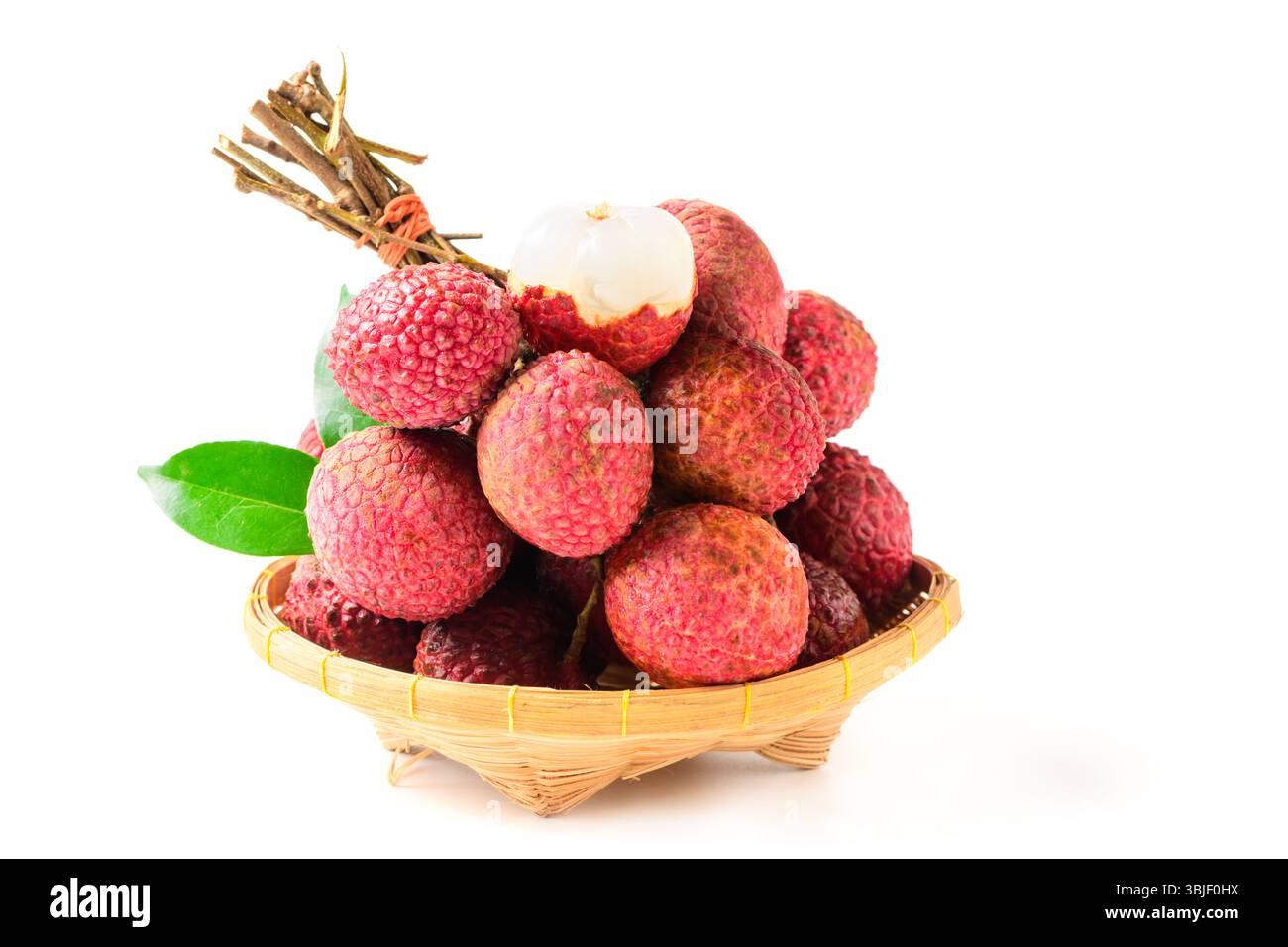 Juicy Lychee with cut in half and leaves on bamboo basket isolated on ...