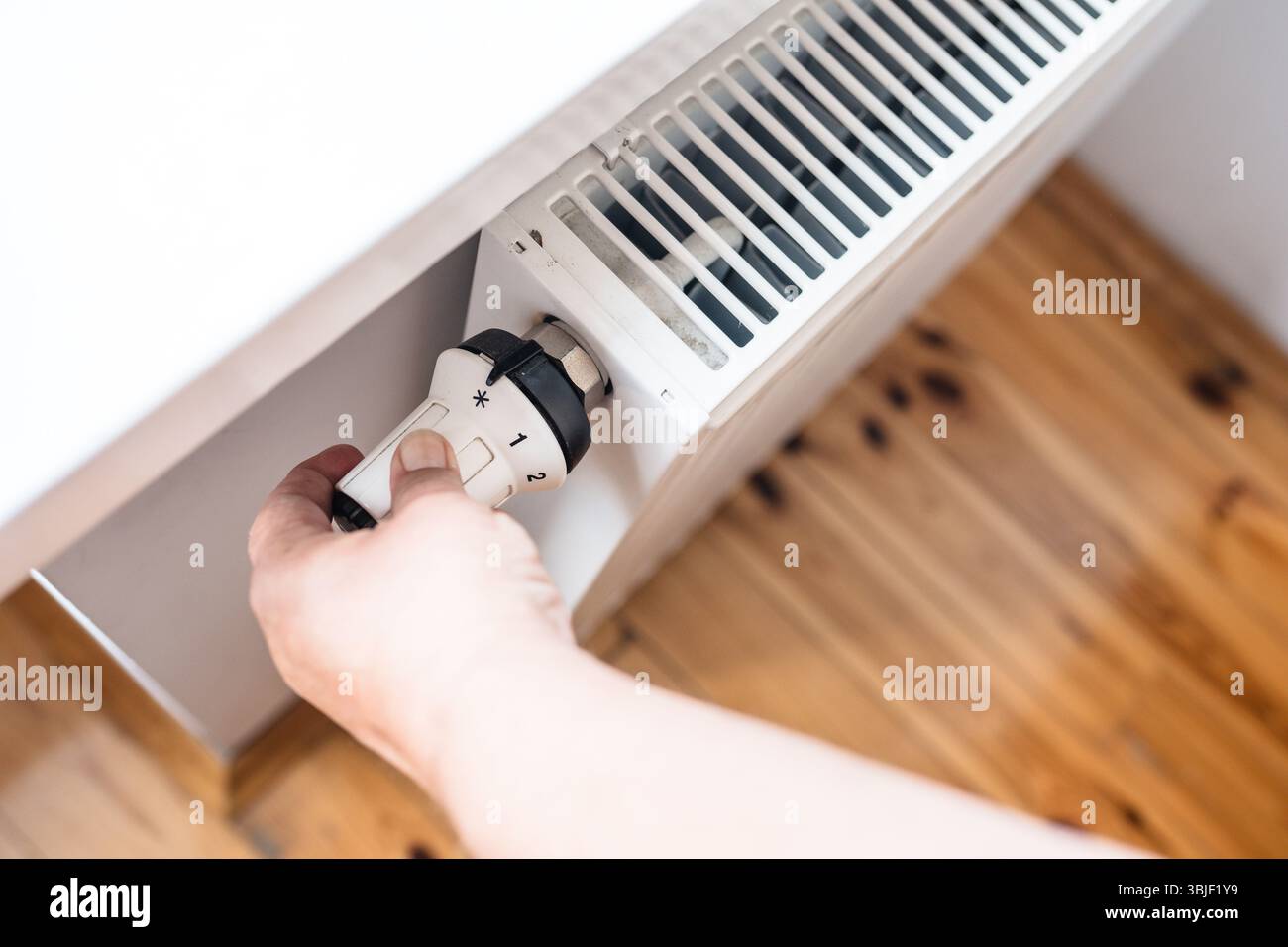 Hand regulates the heat in the house on the radiator handle Stock Photo ...