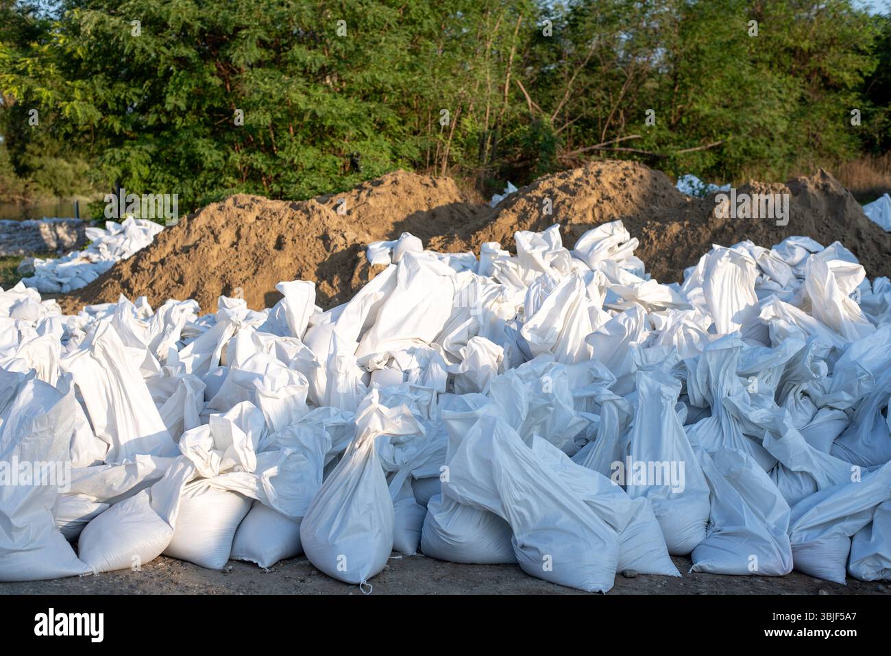 A sack is filled with sand to be used as a wall to prevent flooding in ...