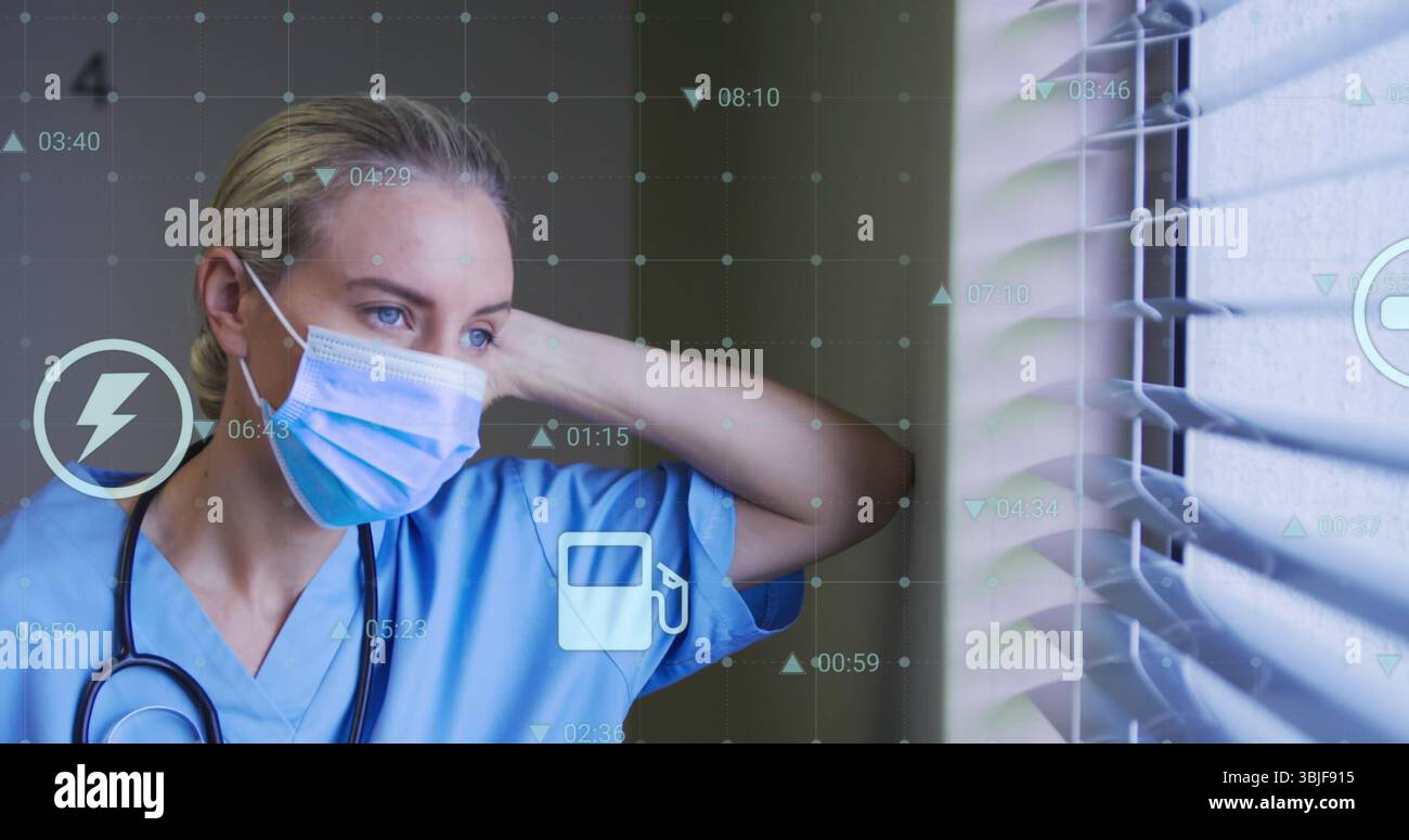Gazing nurse scanning digital grid through blinds at medical facility ...
