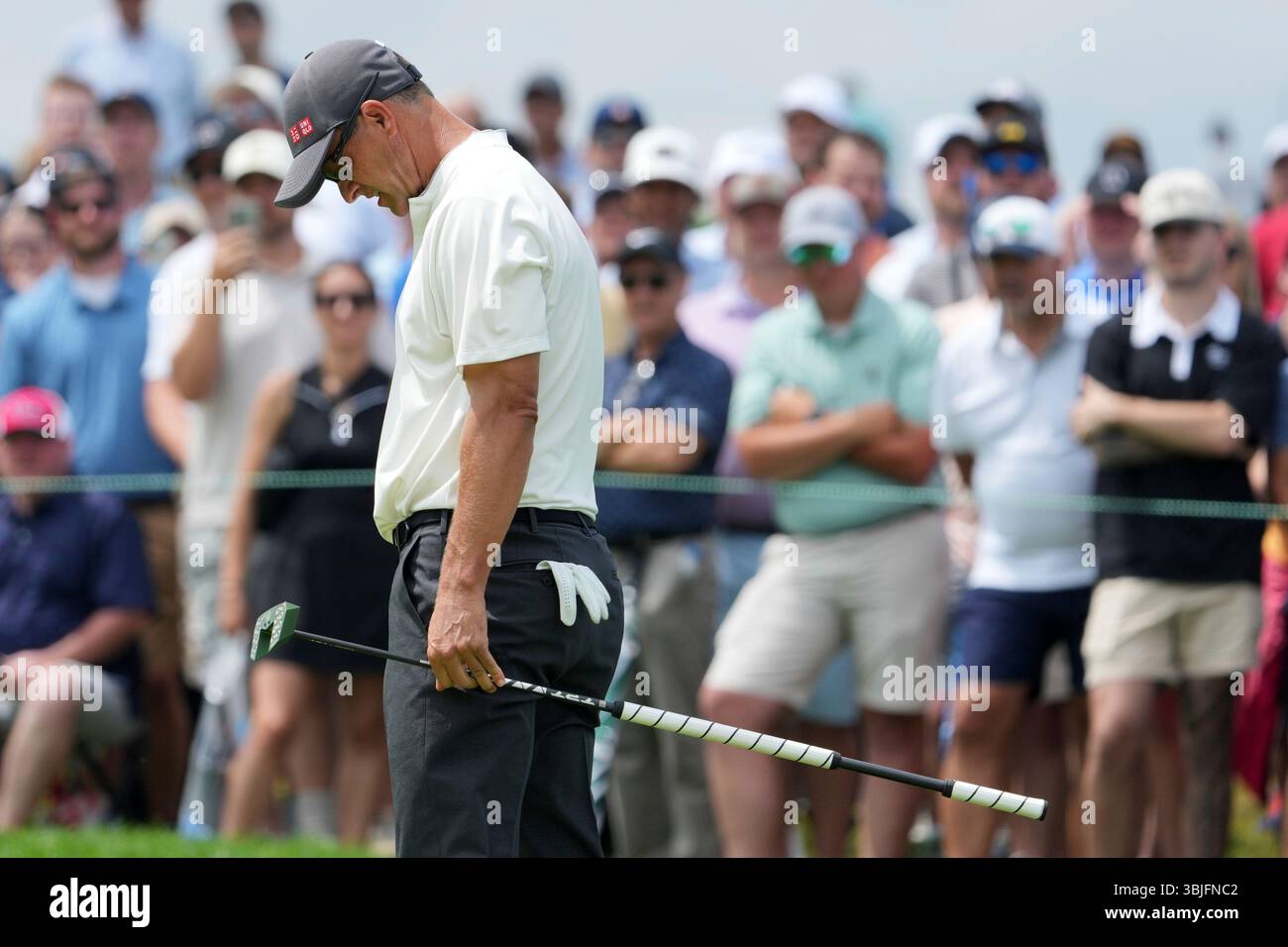 Adam Scott, of Australia, reacts to missing a putt on the first hole ...