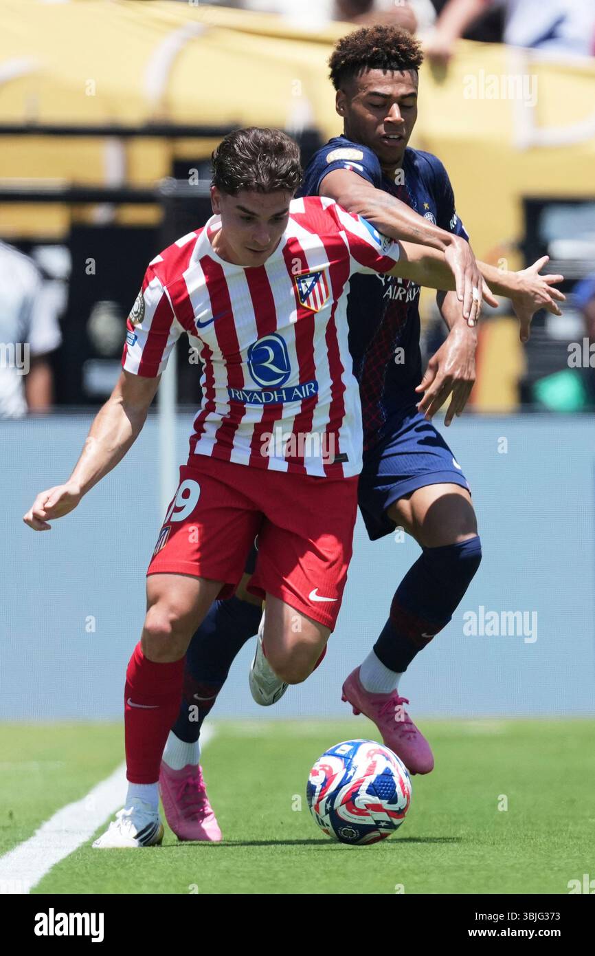 Paris Saint-Germain's Desire Doue, right, and Atletico Madrid's Julian Alvarez battle for the ...