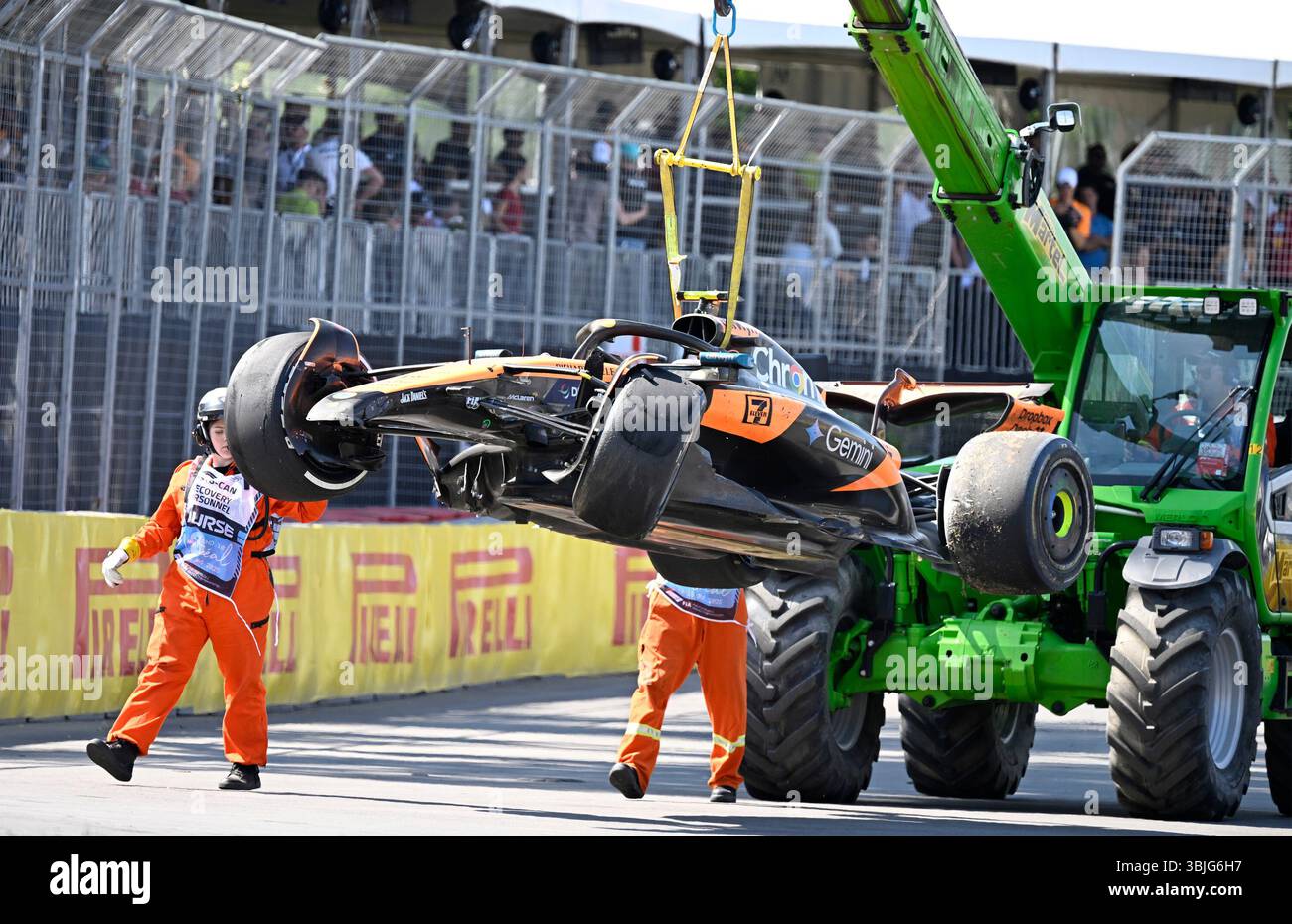 Track recovery personnel lift Lando Norris' McLaren after he hit the ...