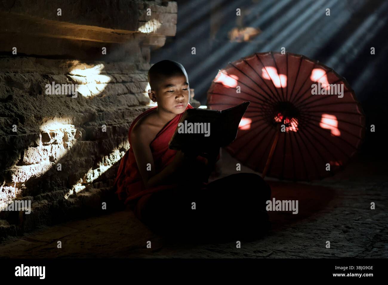 Novice Monk sitting in a temple reading a book, Bagan, Myanmar Stock ...
