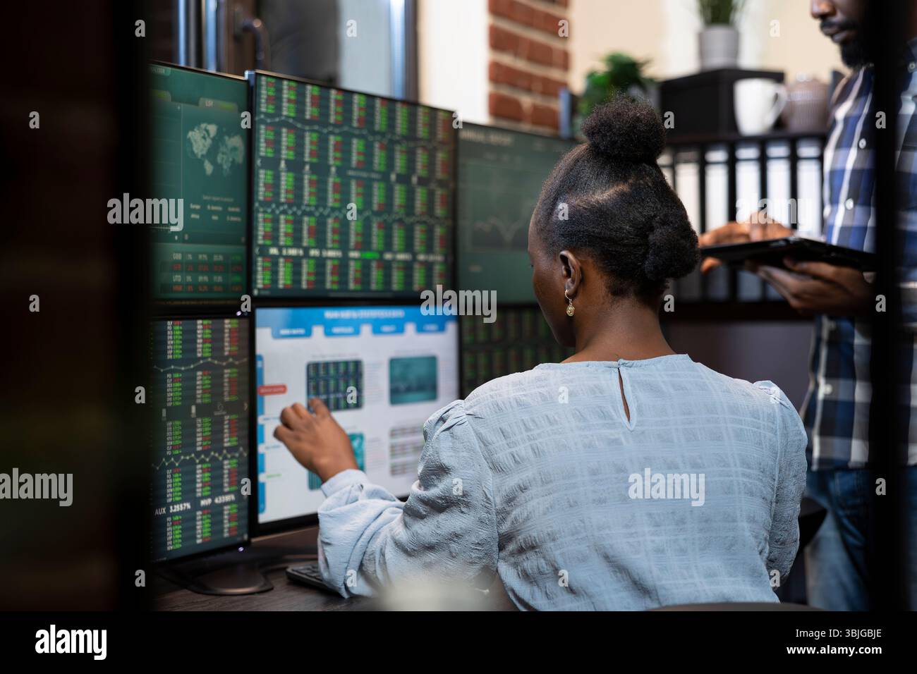 Female stock exchange advisor pointing at computer screen as she ...
