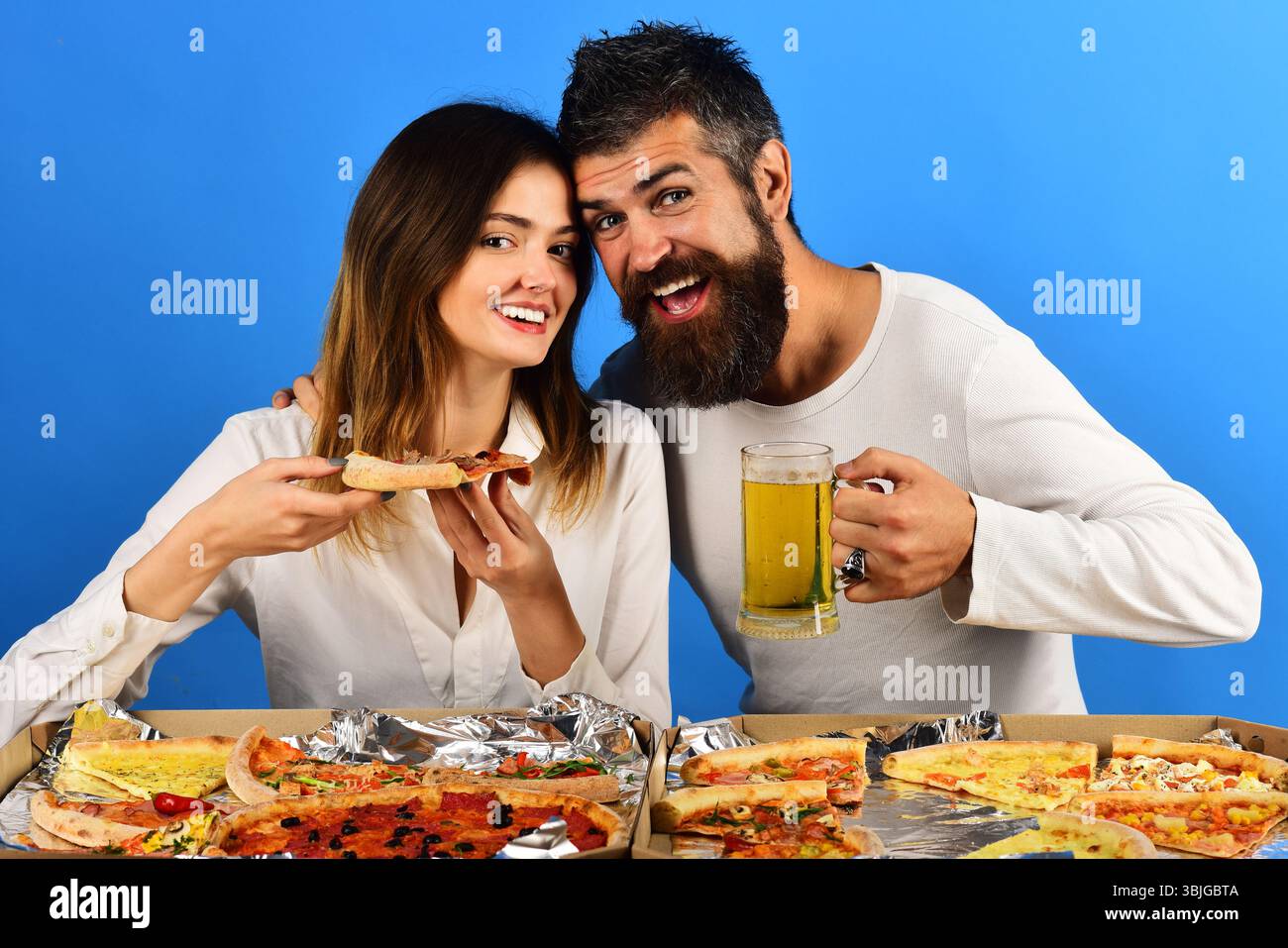Pizza time. Couple in love eating pizza and drinking beer. Man drinking ...