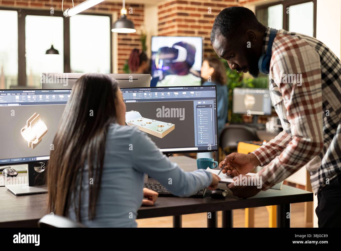 Professional male and female engineers designing an industrial engine prototype with CAD tools ...