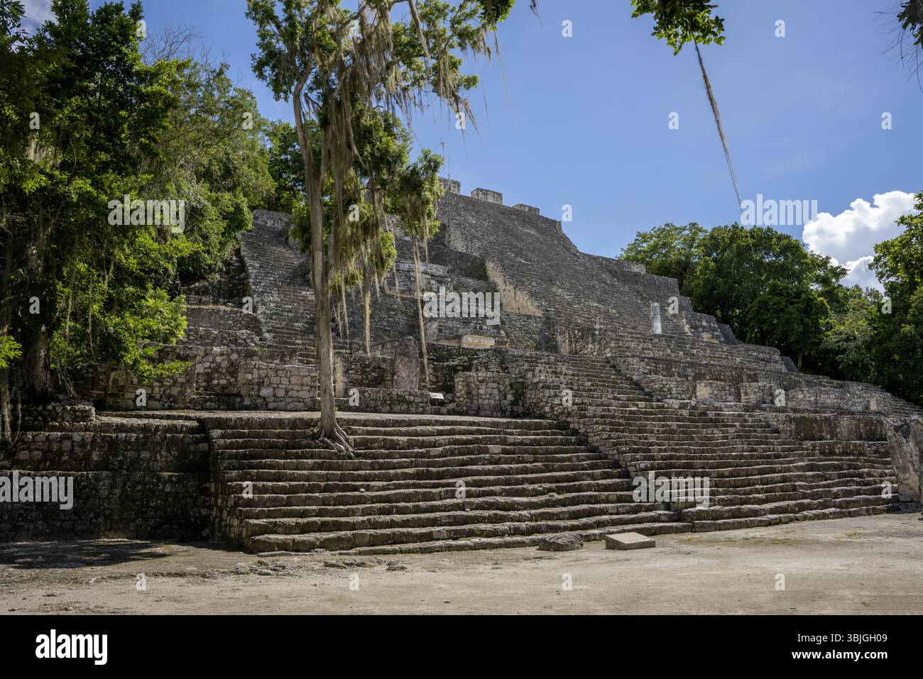 Maya Structure II large stone pyramid with stepped terraces under blue ...