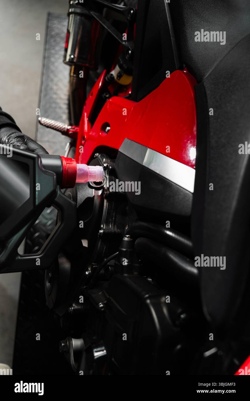 Precision oil fill operation on a red sportbike to ensure proper engine ...