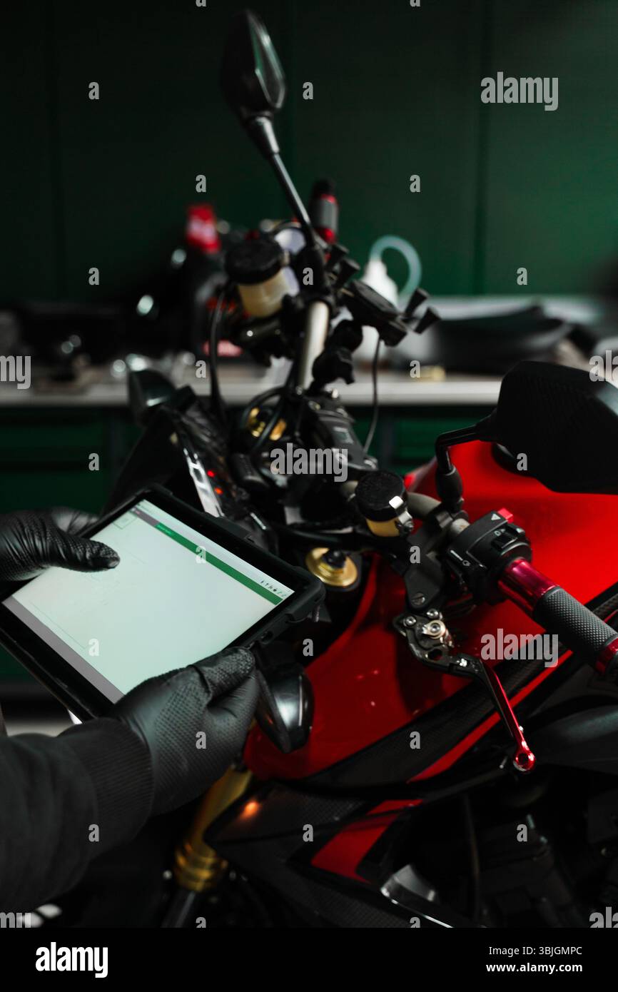 Mechanic performing system diagnostics via tablet. Motorcycle system ...