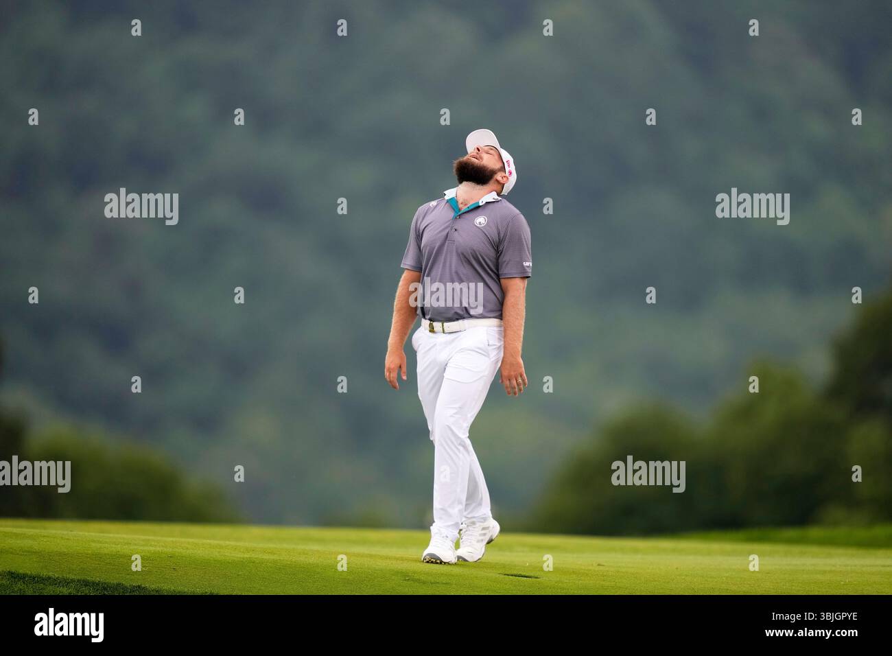 Tyrrell Hatton, of England, reacts after hitting his ball into the ...