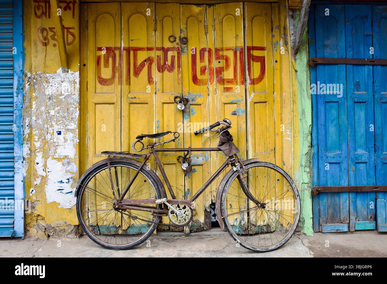 Locked yellow shopfront in Jessore, Bangladesh, with hand painted ...