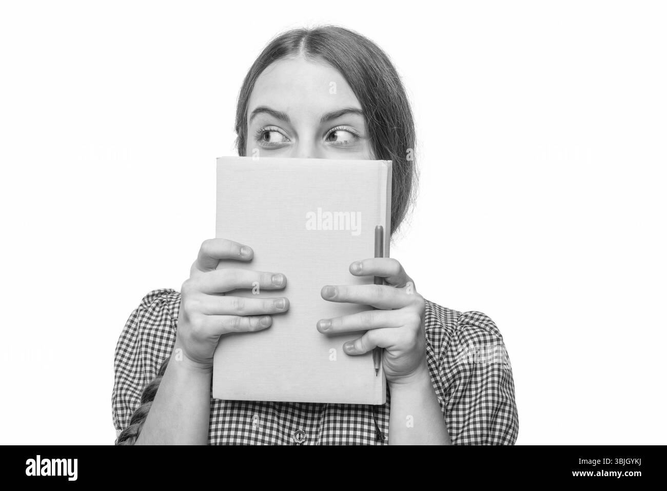 Teen school girl hiding behind reading education book to get knowledge ...