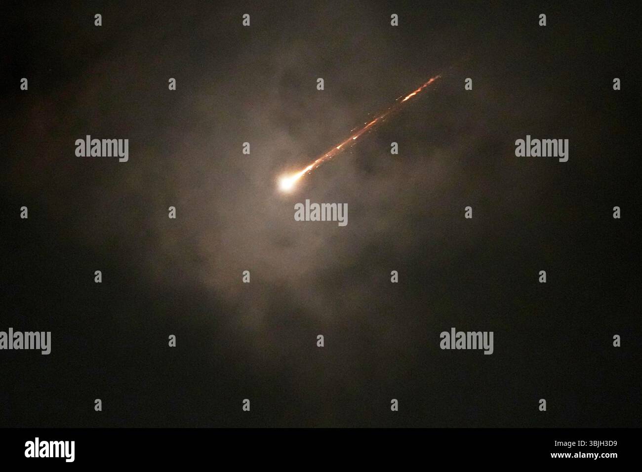 The trail of a projectile is seen through the clouds following a ...