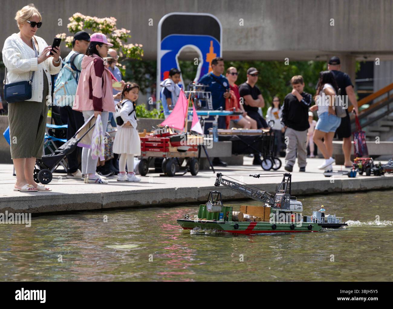 Toronto, Canada. 15th June, 2025. People watch a model boating race ...