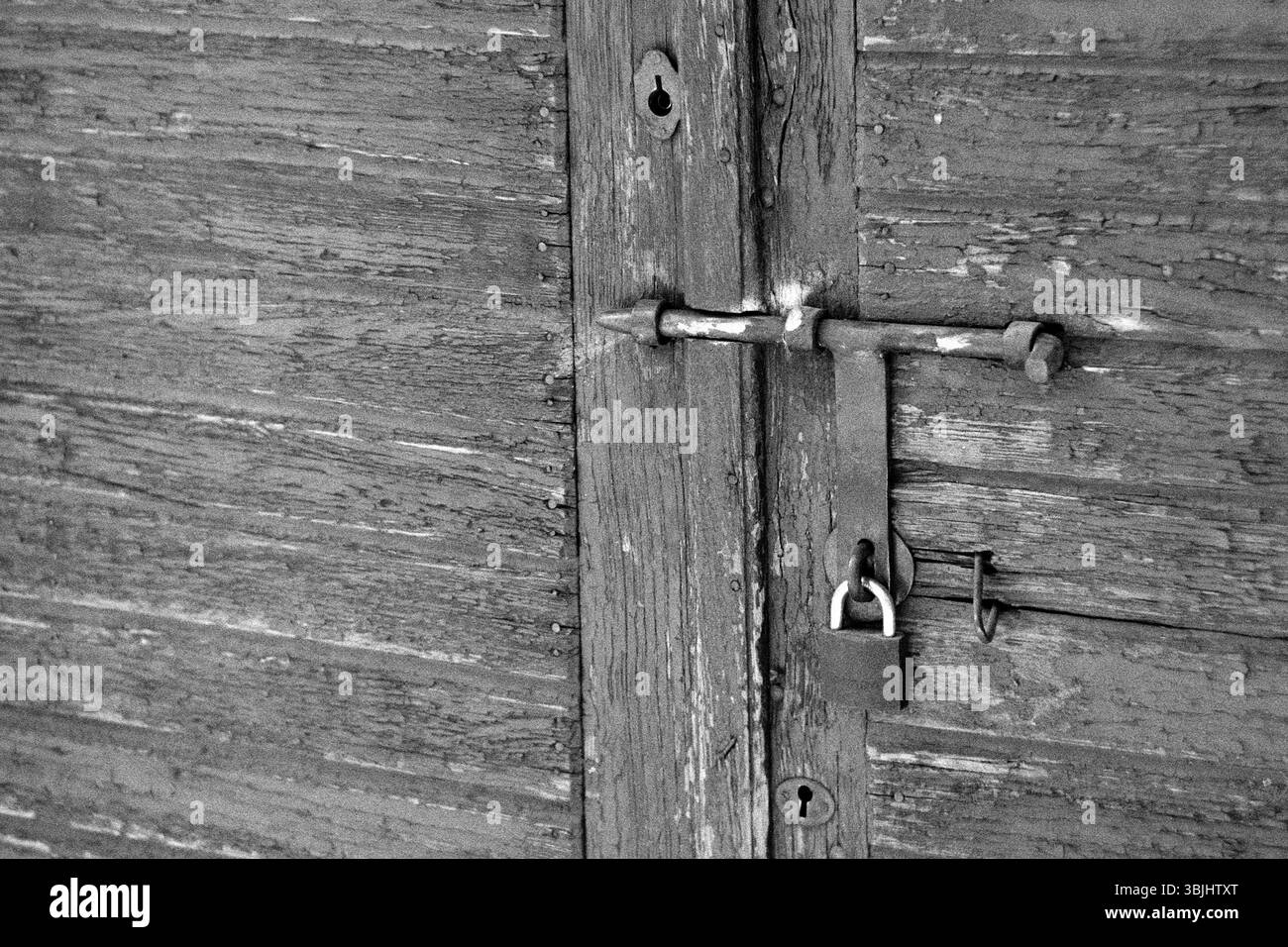 Black-and-white photo of the old wooden door with a lock and latch ...
