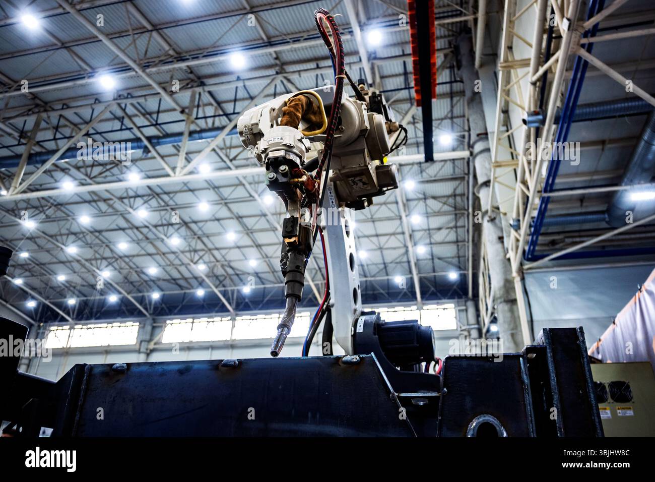 Industrial robotic welding arm operating in manufacturing facility ...