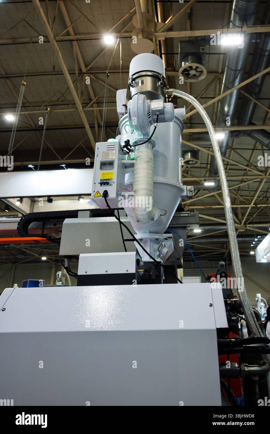 Close-up of a plastic injection molding machine's feeding mechanism in ...