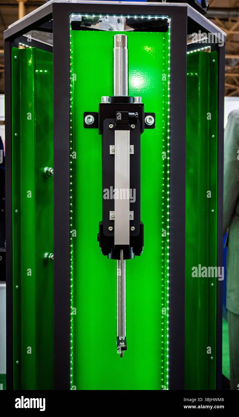 Vertical linear actuator mechanism in bright green illuminated ...