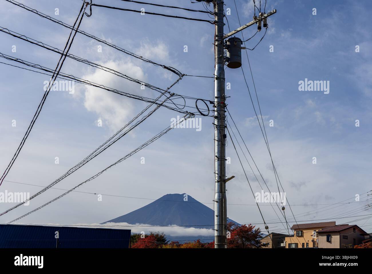 Endless power lines weave across the sky framing Mount Fuji as it ...