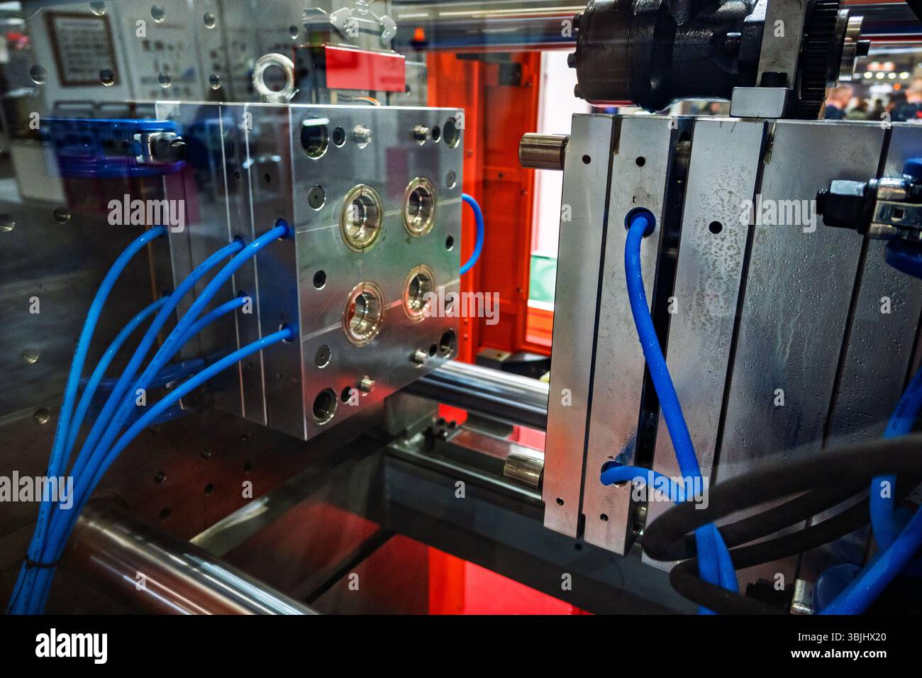 Close-up view of a shiny metal injection molding tool or die with blue ...