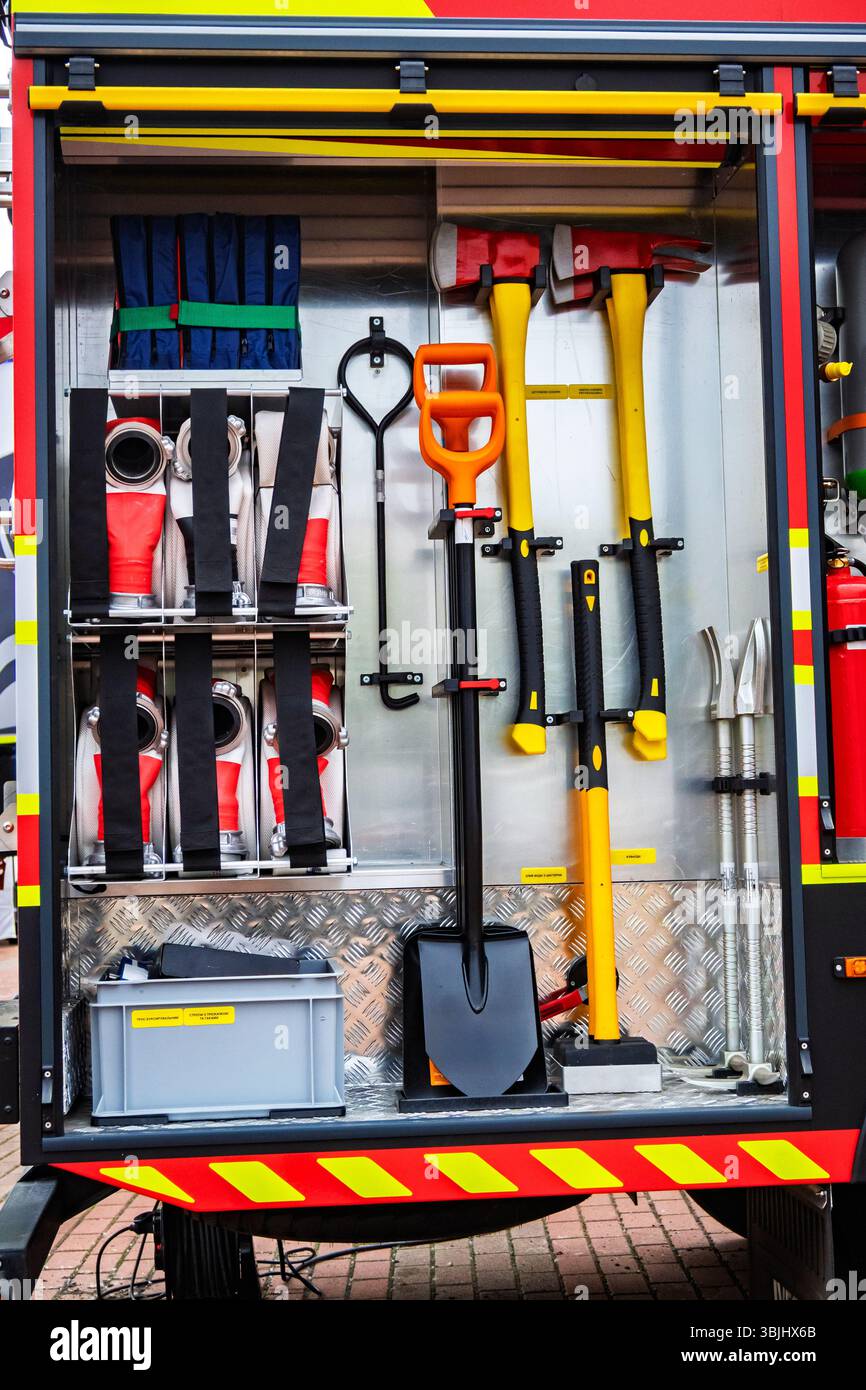 Close-up view of a fire truck compartment showcasing essential firefighting equipment, including ...